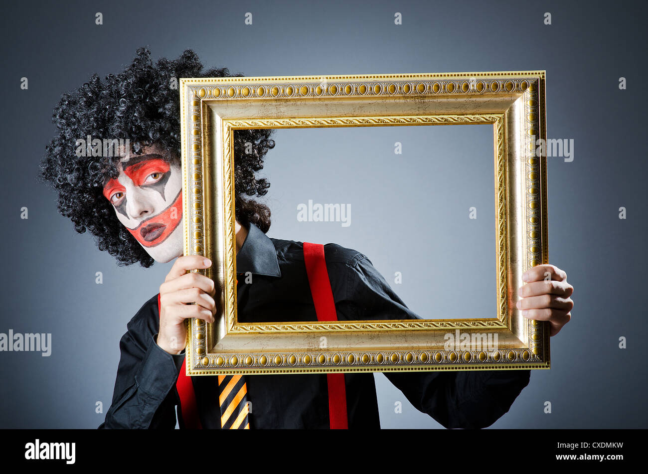 Clown with picture frames in studio Stock Photo - Alamy