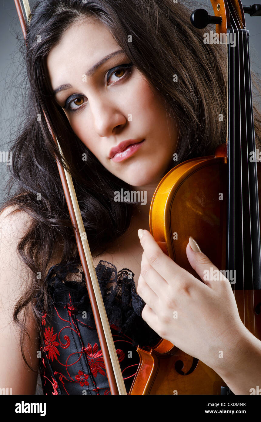 Female violin player against background Stock Photo - Alamy
