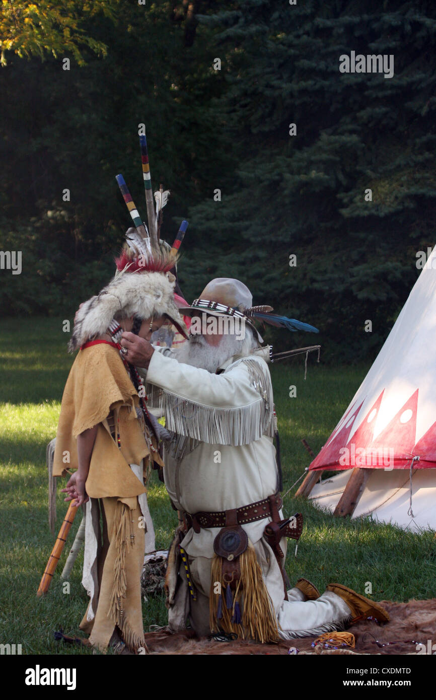 A young Native American Indian boy receiving a gift of a necklace from ...