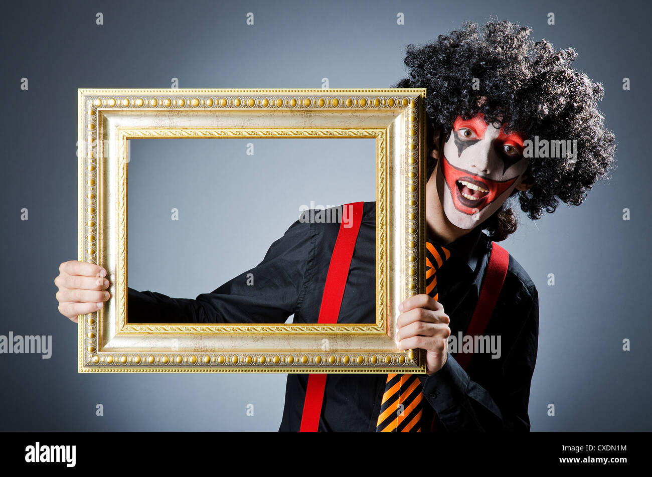 Clown with picture frames in studio Stock Photo - Alamy