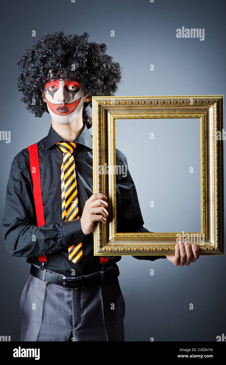 Clown with picture frames in studio Stock Photo - Alamy
