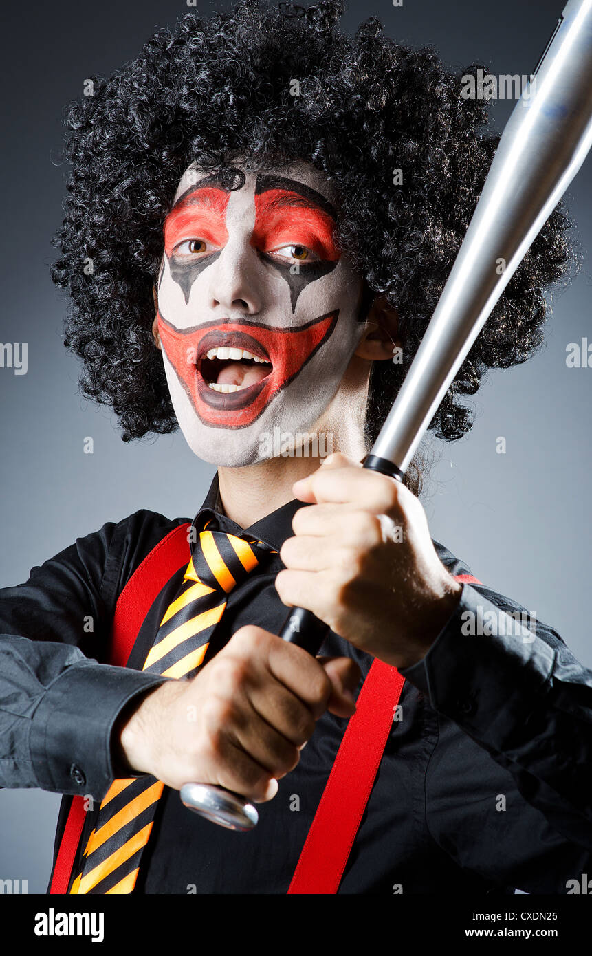 Funny clown with bat in studio Stock Photo - Alamy