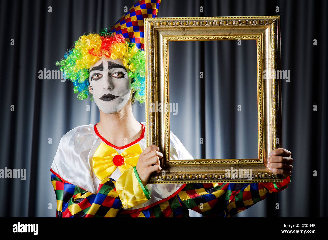 Clown with picture frames in studio Stock Photo - Alamy
