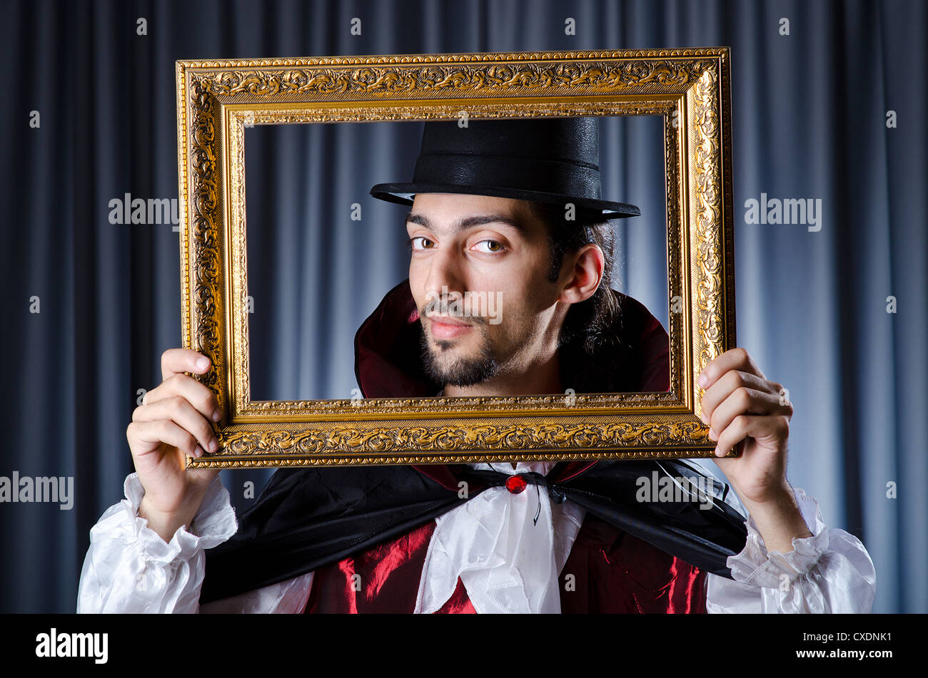 Magician with photoframe in studio Stock Photo - Alamy