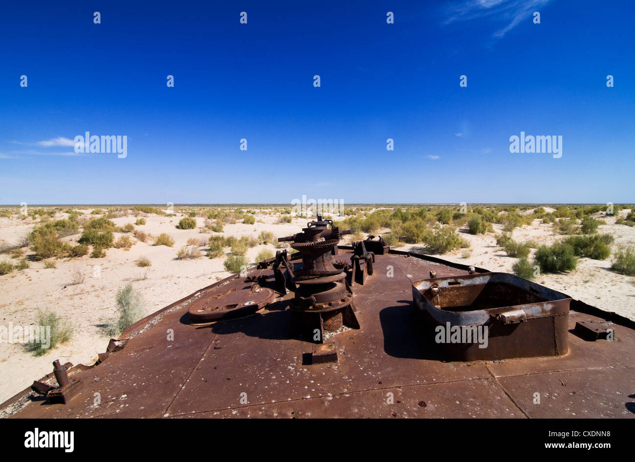 Rusty boats lay still on the dry desert sea bed of the dried Aral sea ...