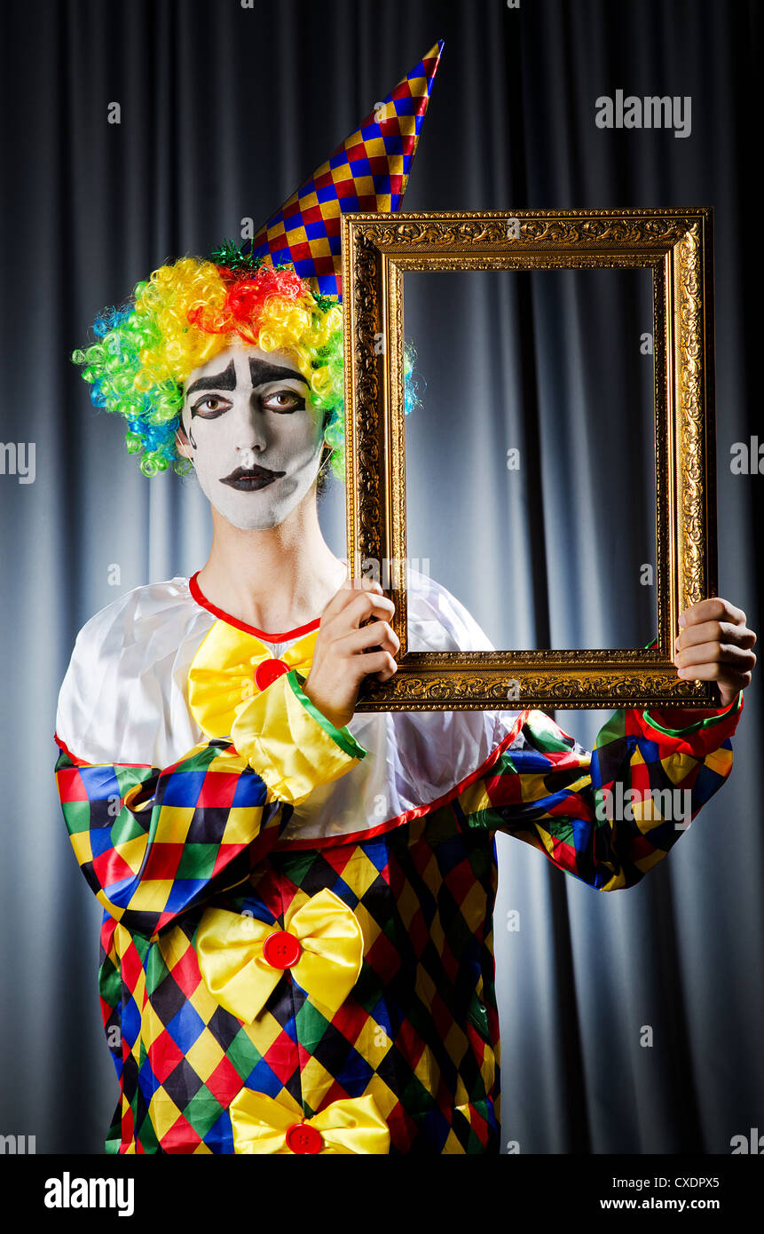 Clown with picture frames in studio Stock Photo - Alamy