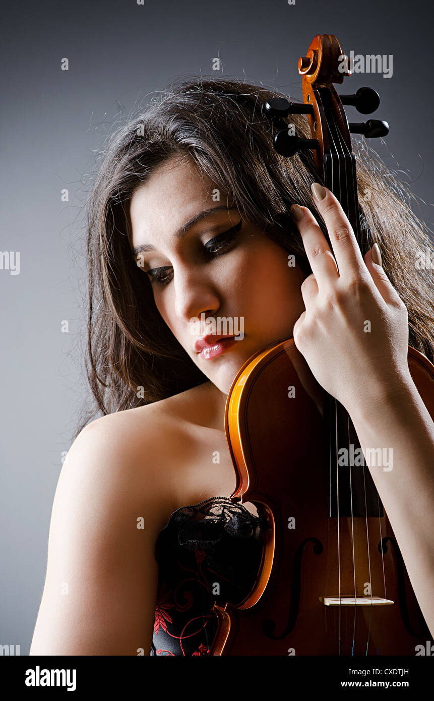 Female violin player against background Stock Photo - Alamy