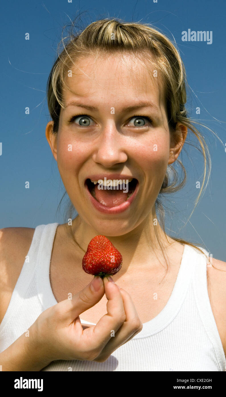 Young woman eating a strawberry, Berlin Stock Photo - Alamy