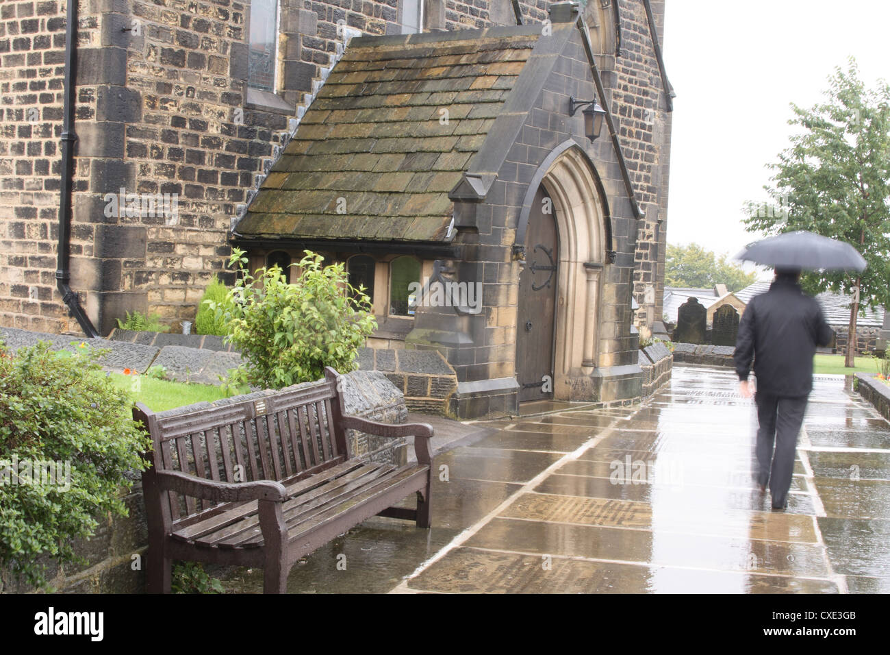 Man walking through church yard in the rain hi-res stock photography ...