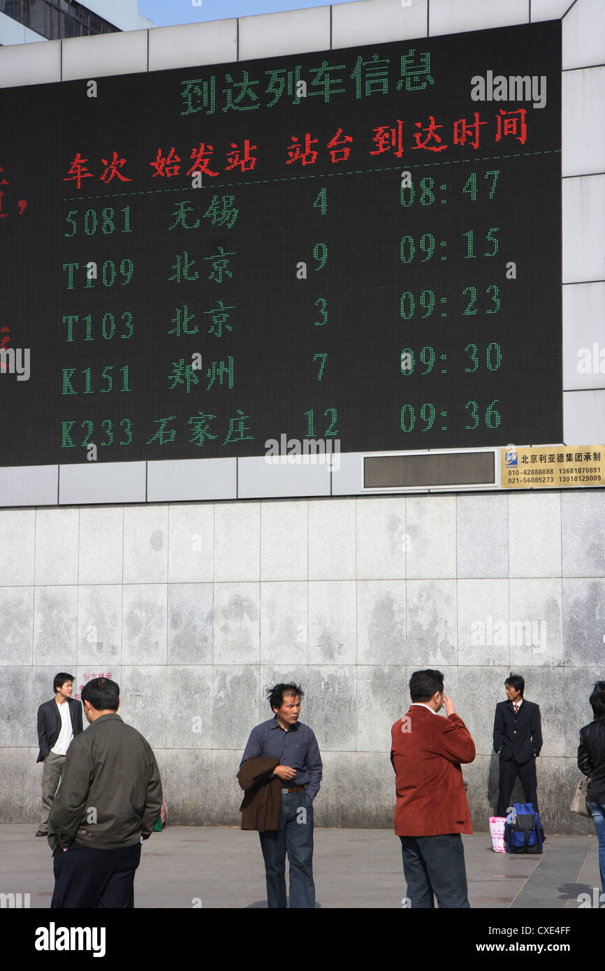 Shanghai Passengers wait at the train station before scoreboard Stock ...