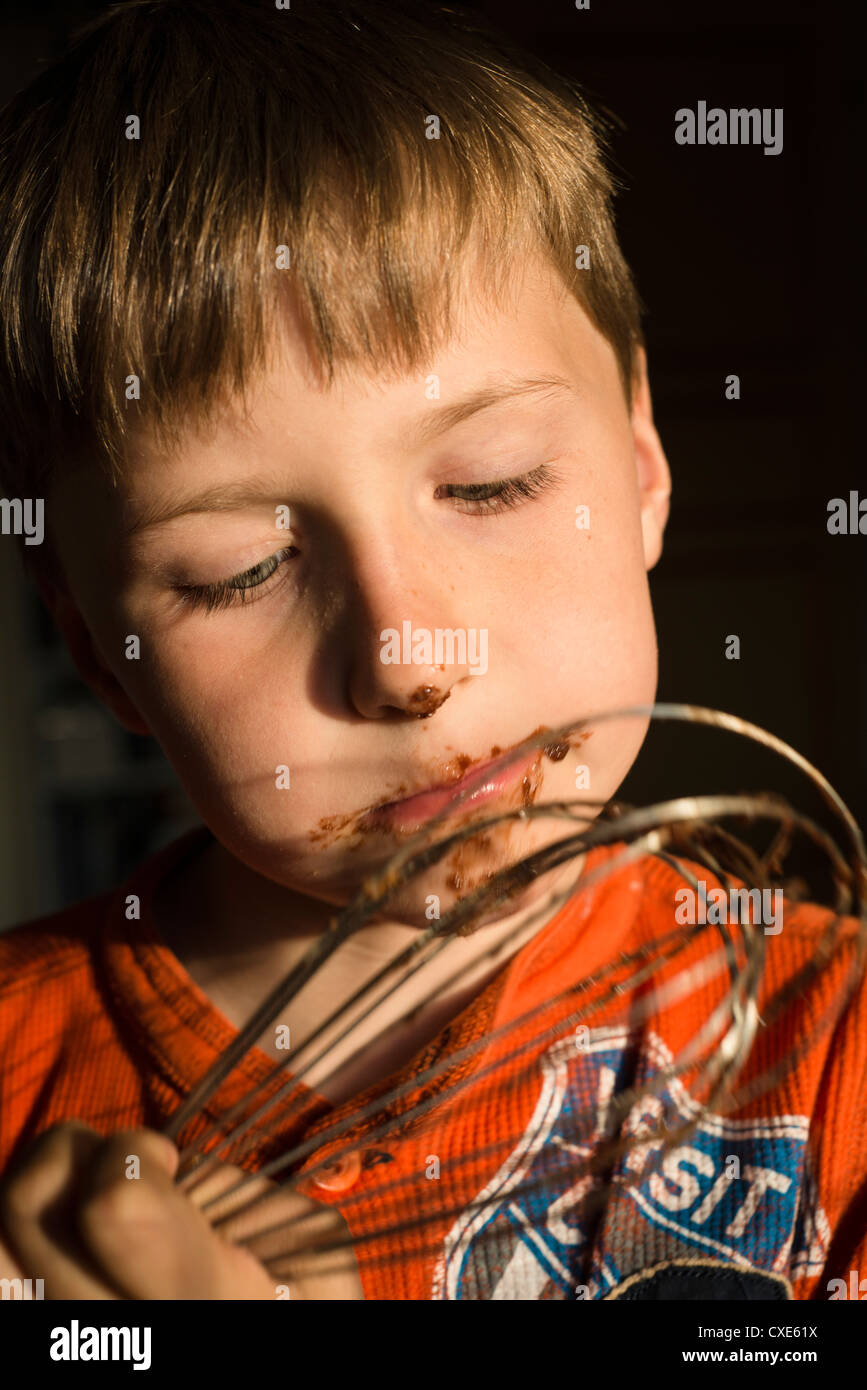 Boy licking chocolate off a beater Stock Photo - Alamy