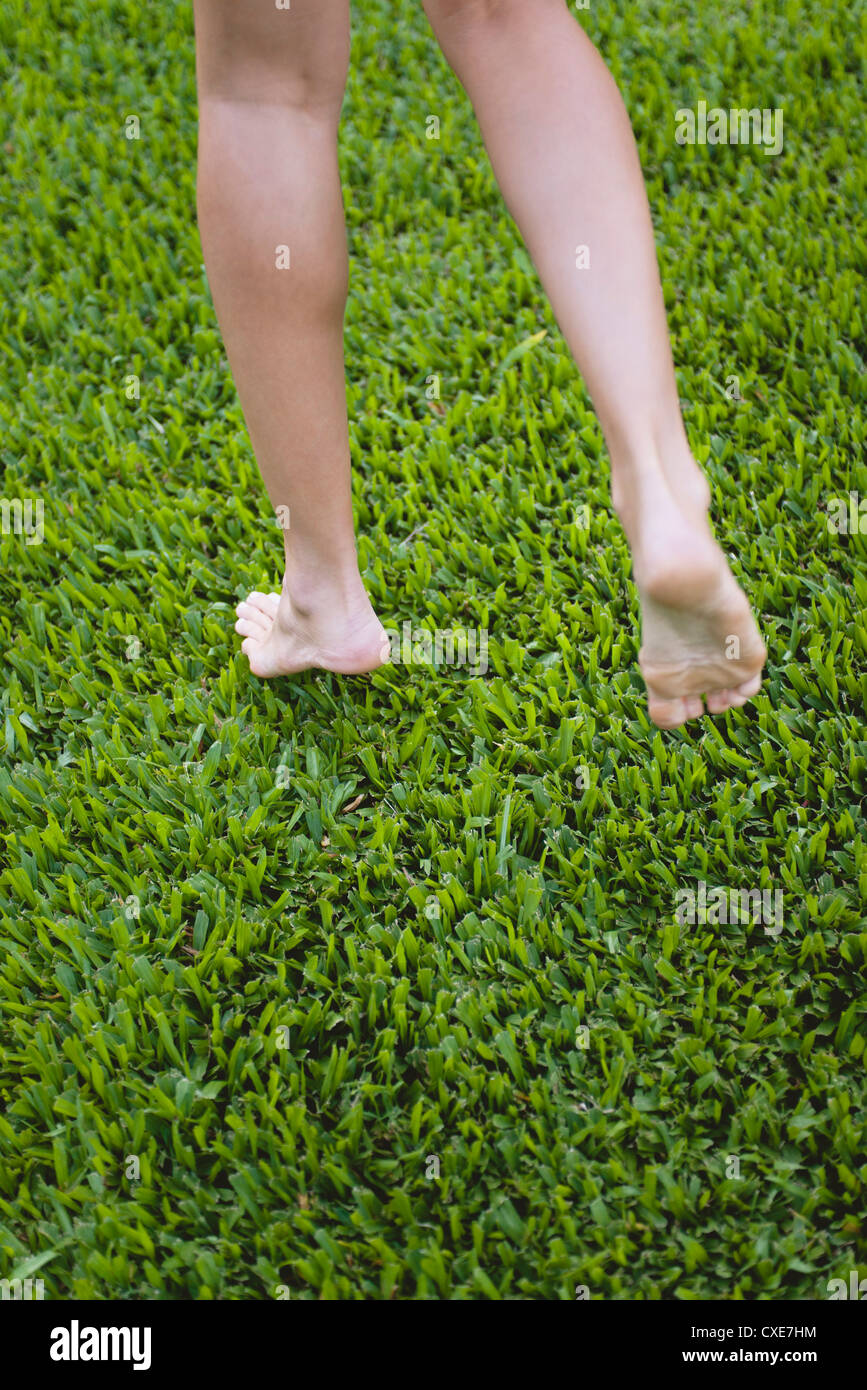 Woman walking barefoot on grass, low section Stock Photo - Alamy
