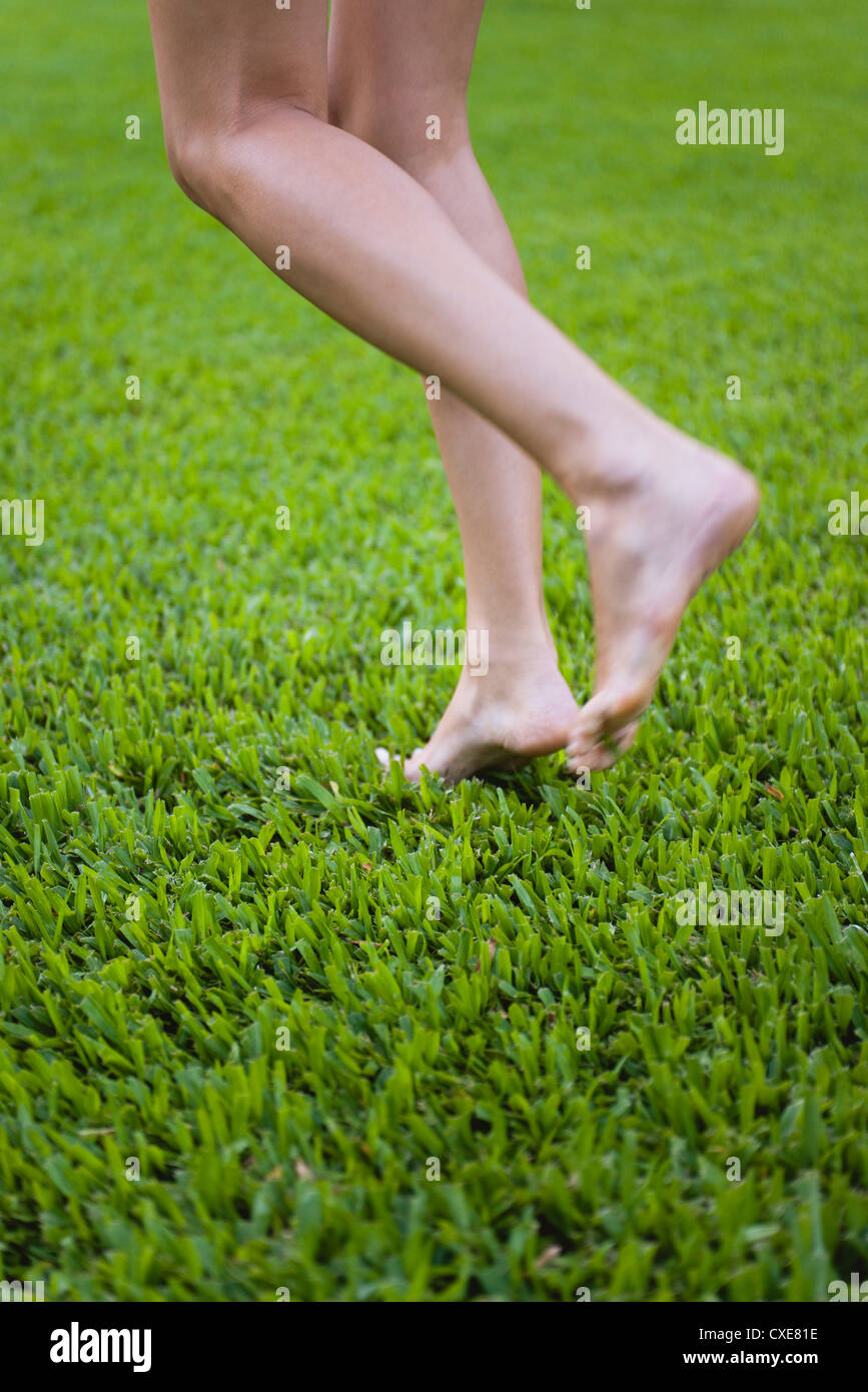 Barefoot woman walking on grass, low section Stock Photo - Alamy