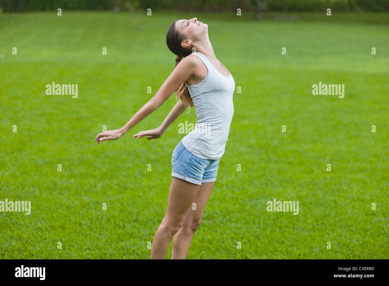 Young woman taking deep breath with arms and head back Stock Photo - Alamy