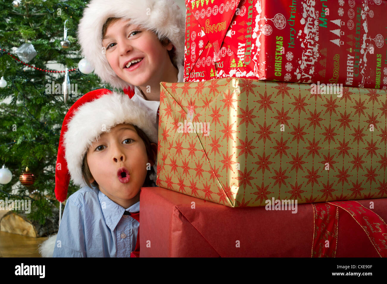 Boy peeking wrapped gifts hi-res stock photography and images - Alamy