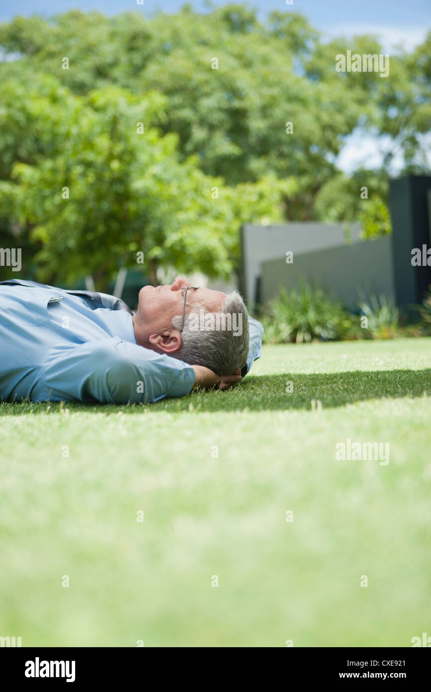 Mature businessman napping on grass Stock Photo - Alamy