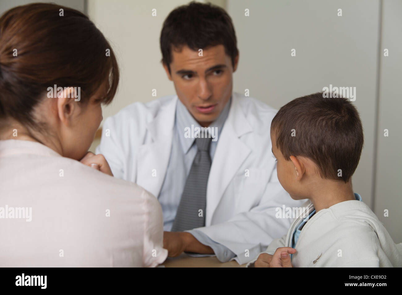 Doctor talking with little boy and woman Stock Photo - Alamy