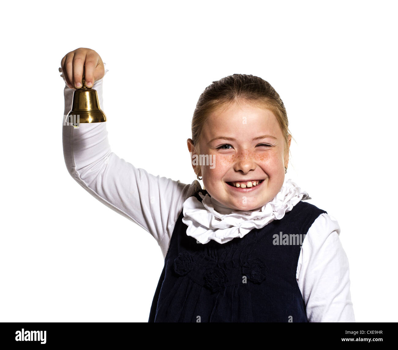 Winking Young school girl ringing a golden bell on white background ...
