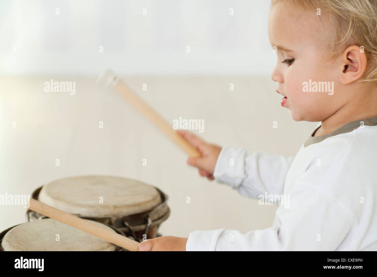 Baby boy playing drums, side view Stock Photo - Alamy