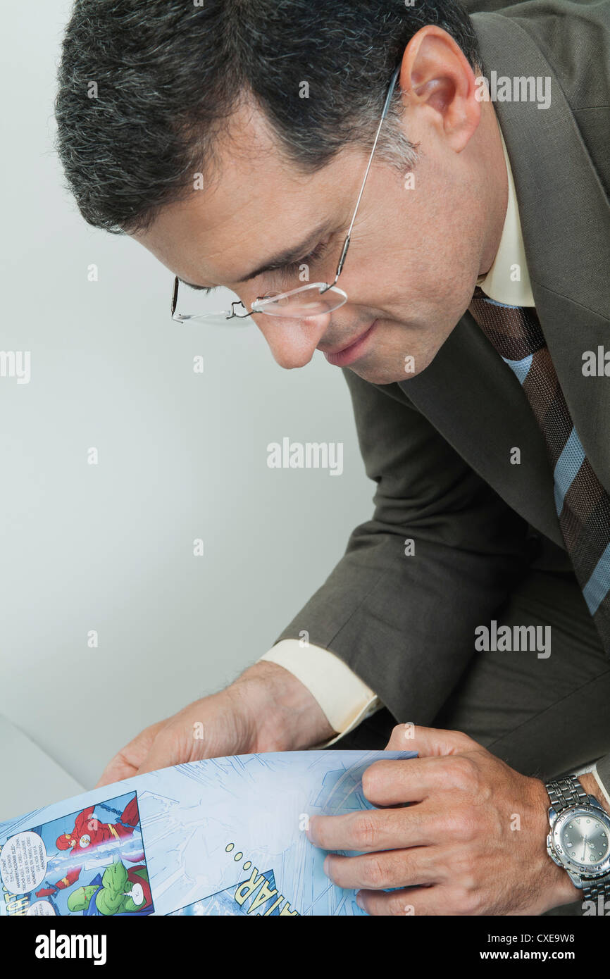 Mature man reading comic book Stock Photo - Alamy