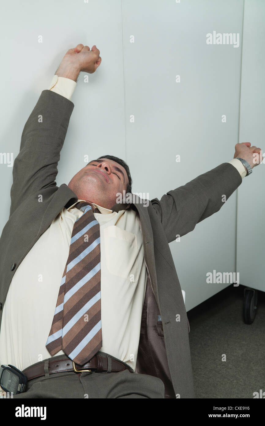 Businessman stretching in office Stock Photo - Alamy
