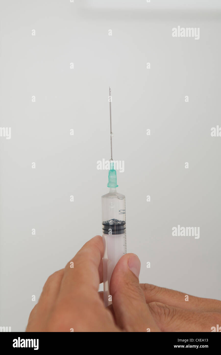 Hand holding syringe Stock Photo - Alamy