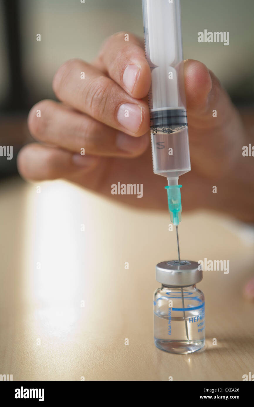 Man filling syringe from vial Stock Photo - Alamy