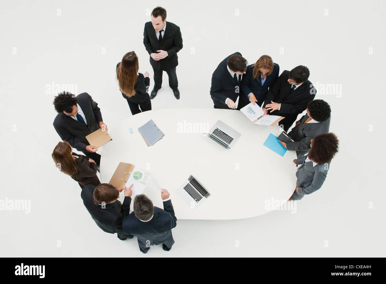 Business associates working together in groups around table Stock Photo ... Business associates working together in groups around table Stock Photo ...