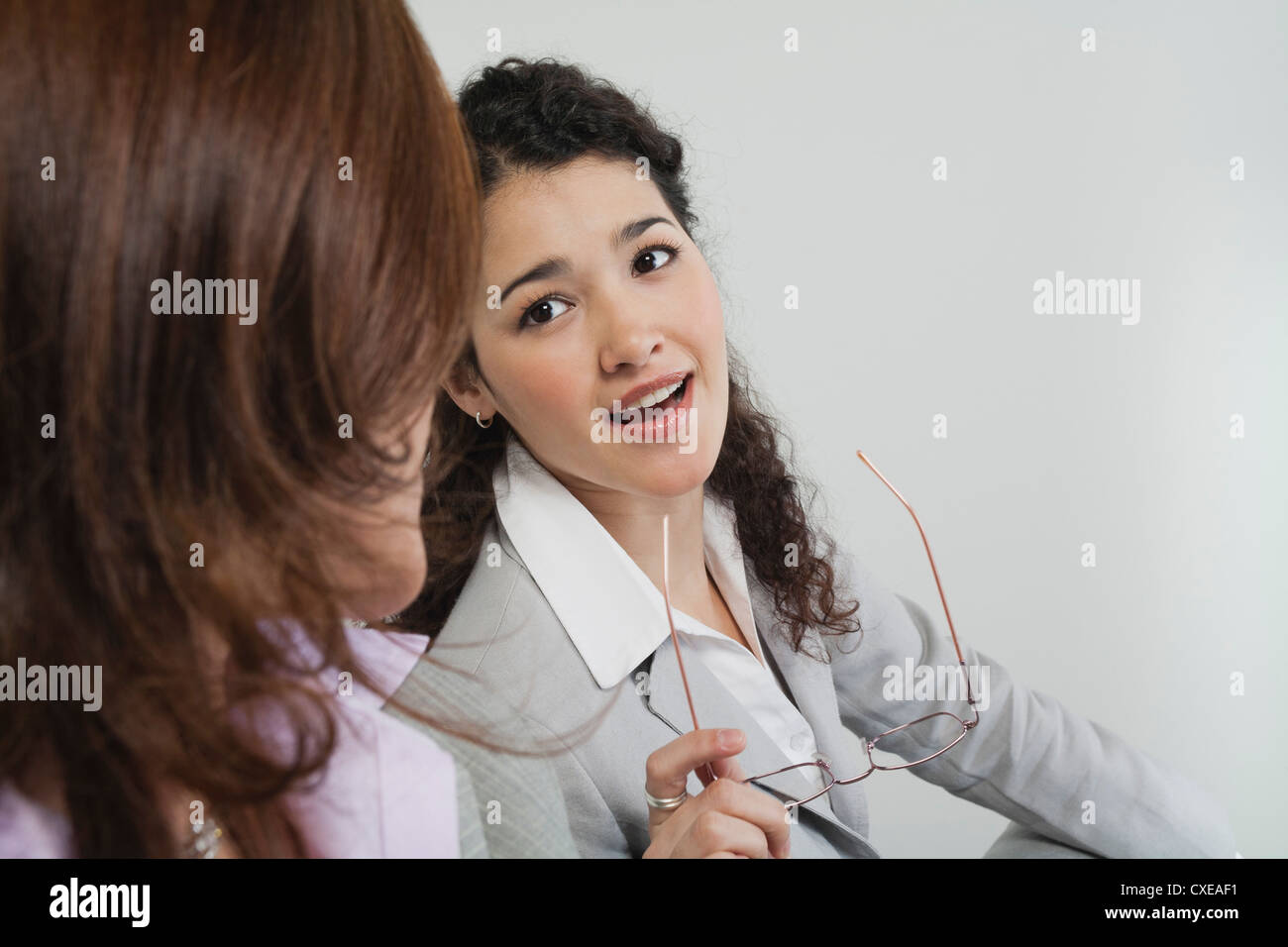 Female colleagues talking together in office Stock Photo - Alamy