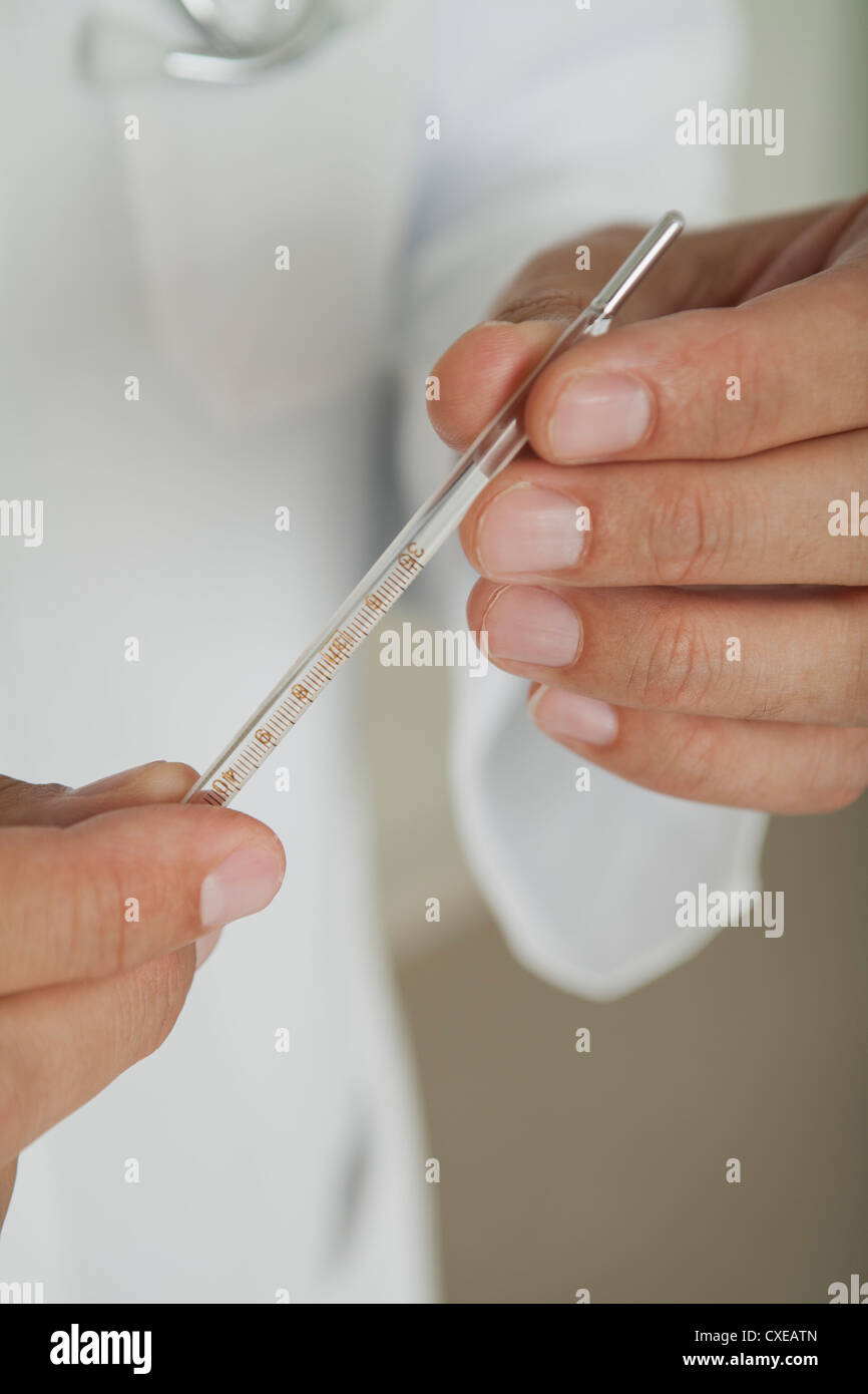 Doctor holding thermometer, cropped Stock Photo - Alamy