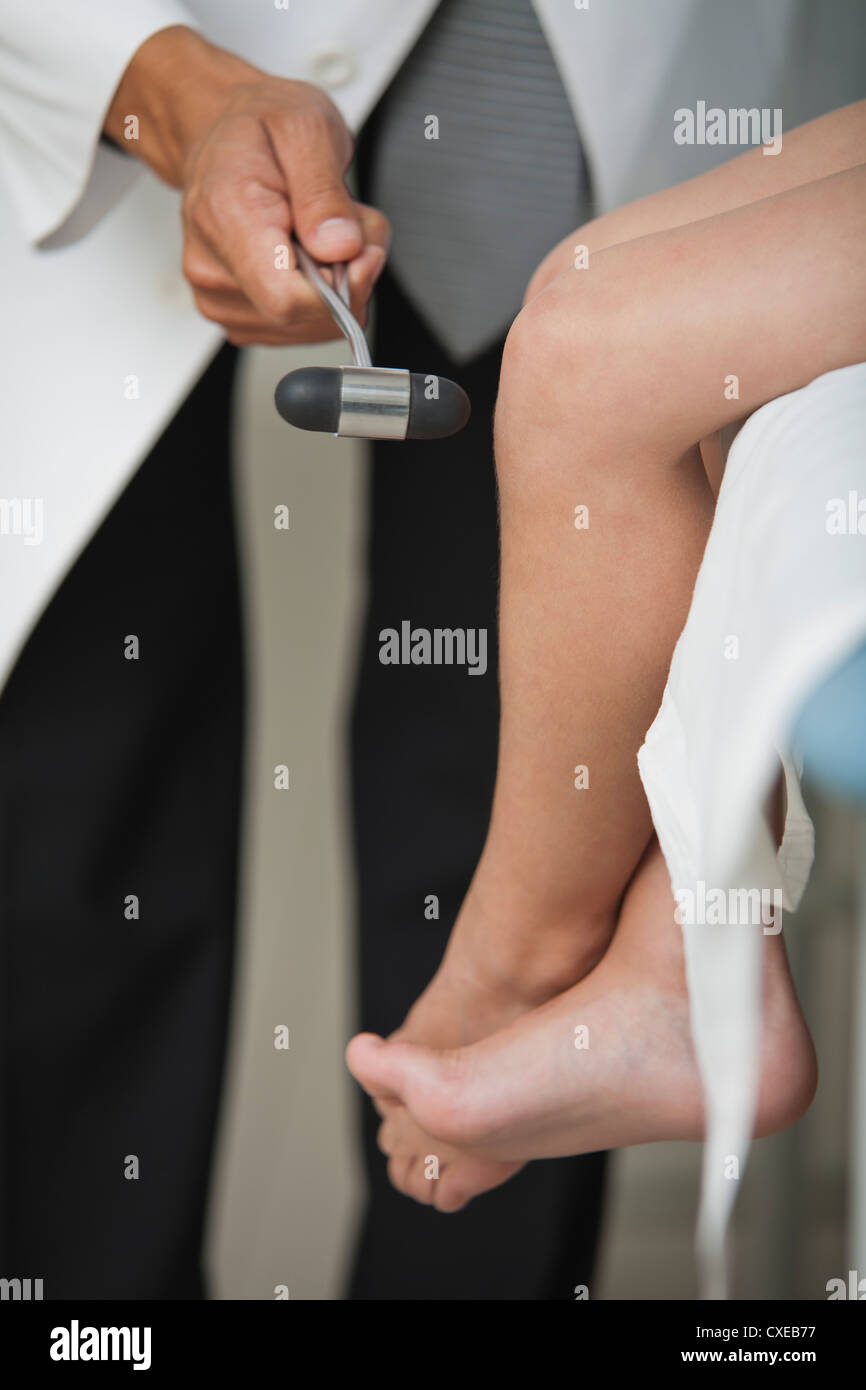 Doctor checking child's reflexes with reflex hammer, cropped Stock ...