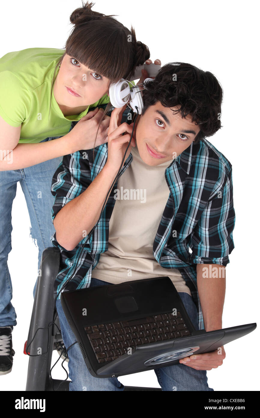 Two teenagers with headphones and computer Stock Photo - Alamy