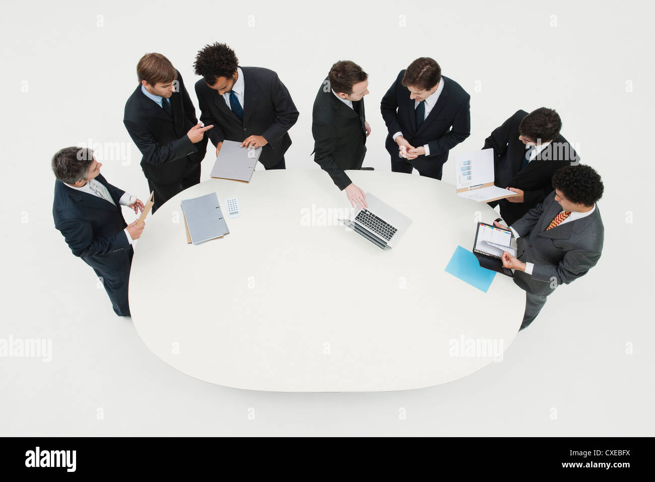 Business associates working together in pairs around table Stock Photo ...