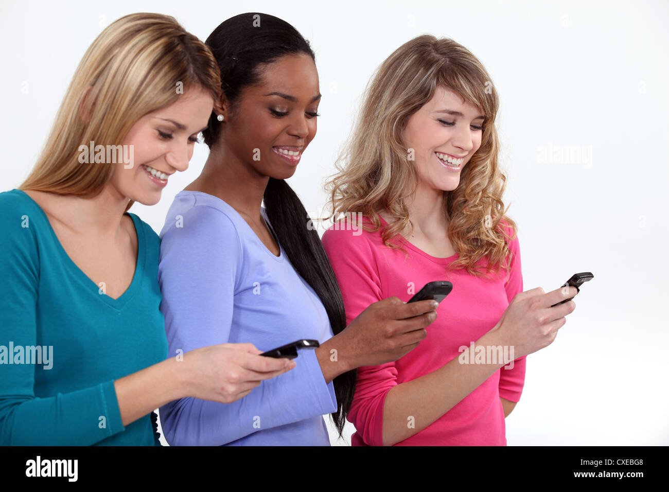 Three female students texting Stock Photo - Alamy