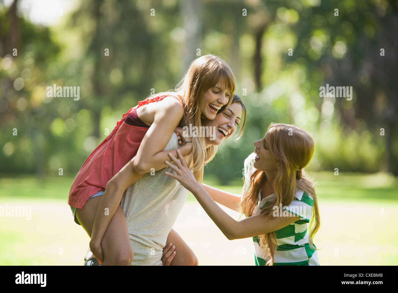 Young women playing, one woman giving another piggyback ride Stock ...