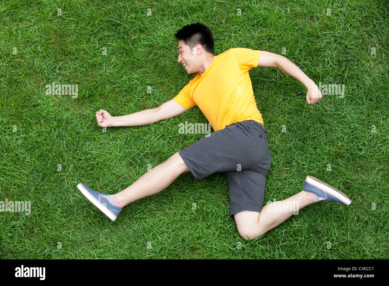 Creative young man imitating running on meadow Stock Photo - Alamy