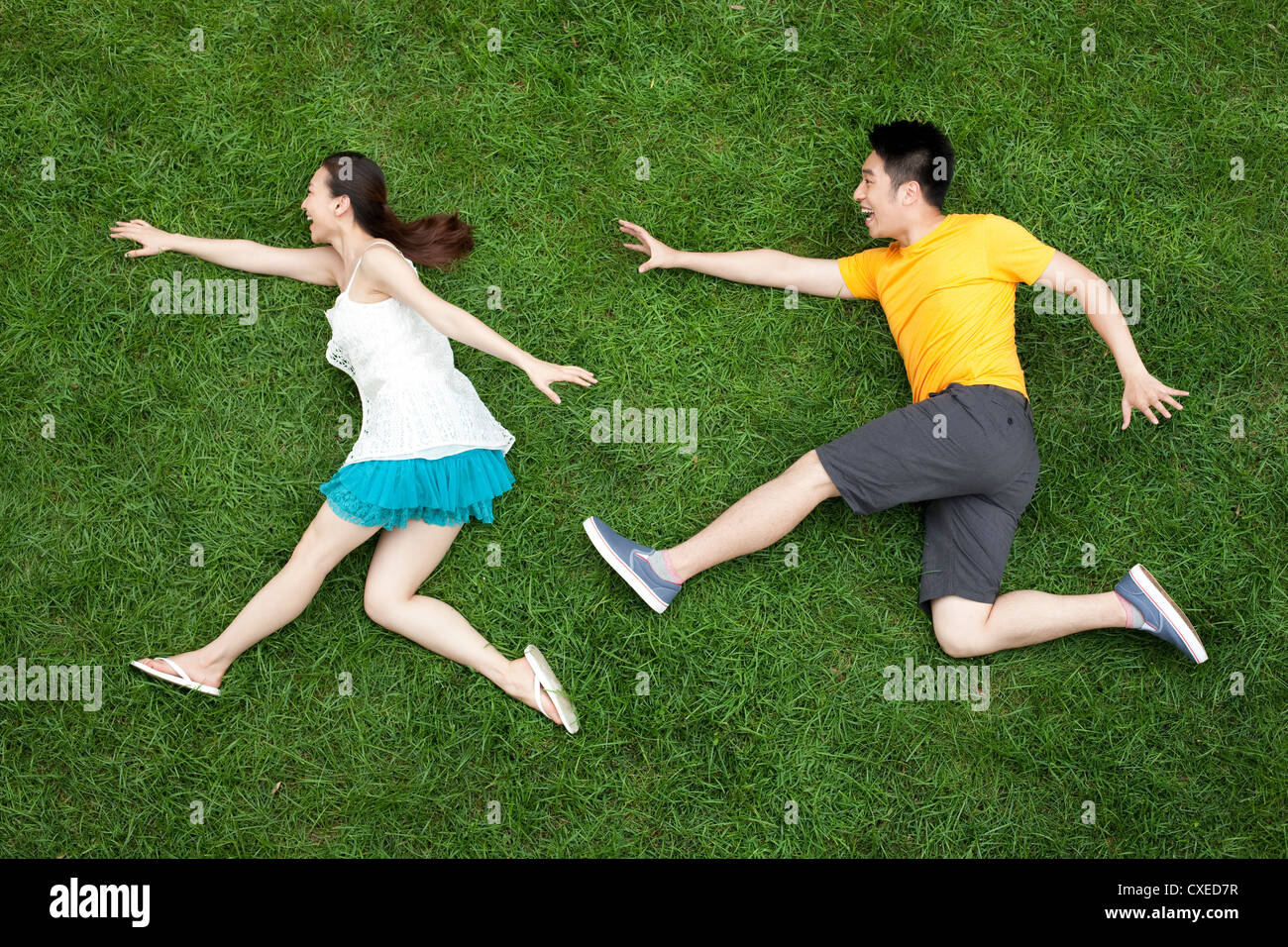 Young couple playing chase game on grass Stock Photo - Alamy