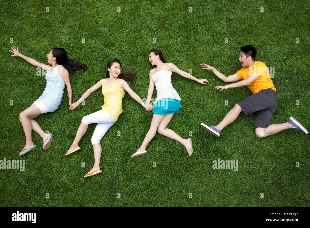 young people playing chase game on grass Stock Photo - Alamy