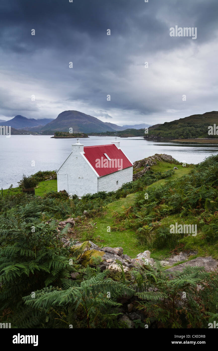 Red roofed white washed cottage overlooks Loch Shieldaig, Wester Ross ...