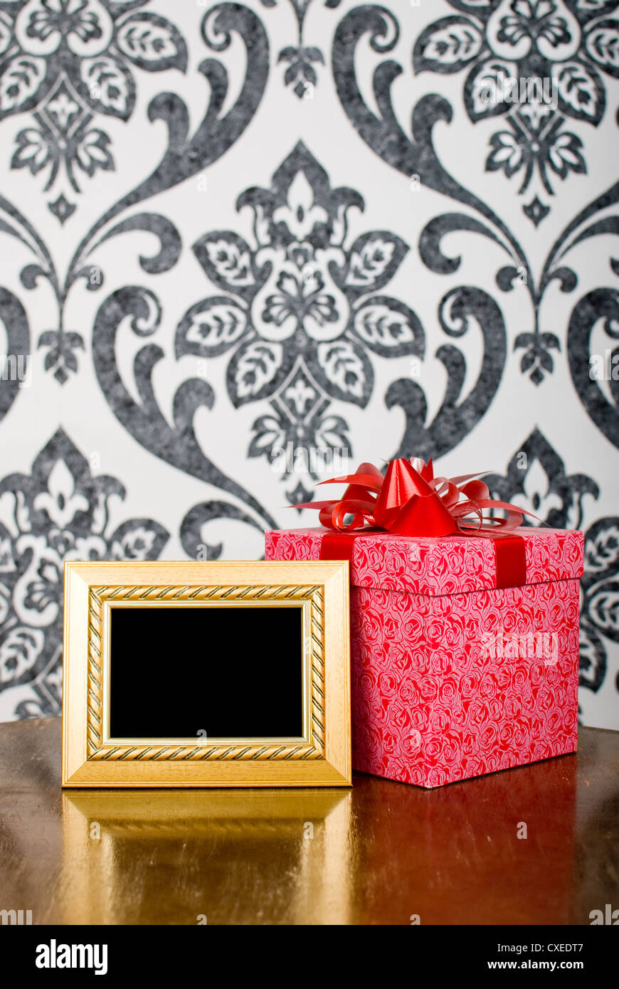 Golden photo frame and present box on table Stock Photo - Alamy