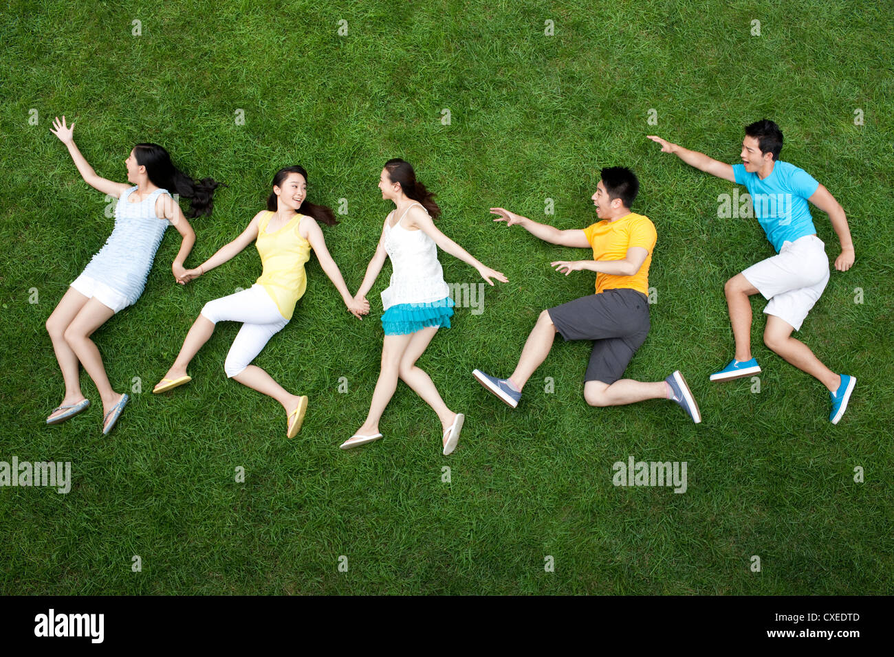 young people playing chase game on grass Stock Photo - Alamy
