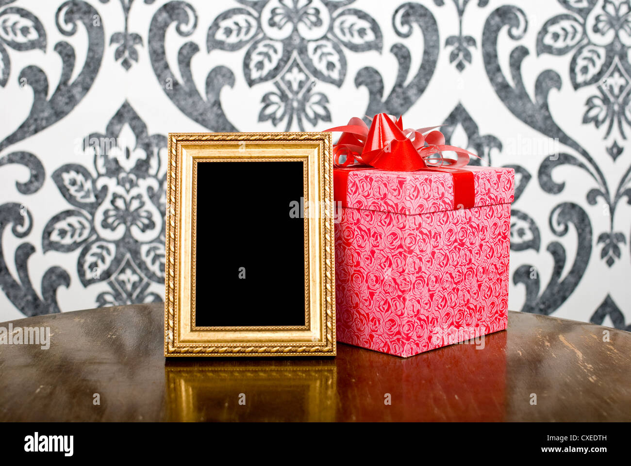Golden photo frame and present box on table Stock Photo - Alamy