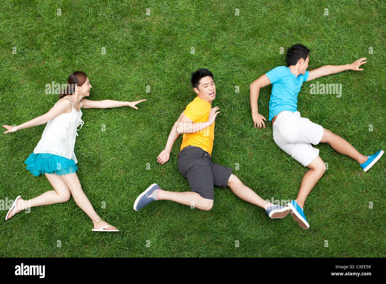 young people playing chase game on grass Stock Photo - Alamy