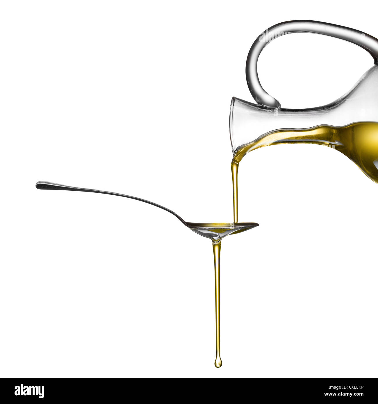 Pouring oil on spoon isolated on white Stock Photo - Alamy