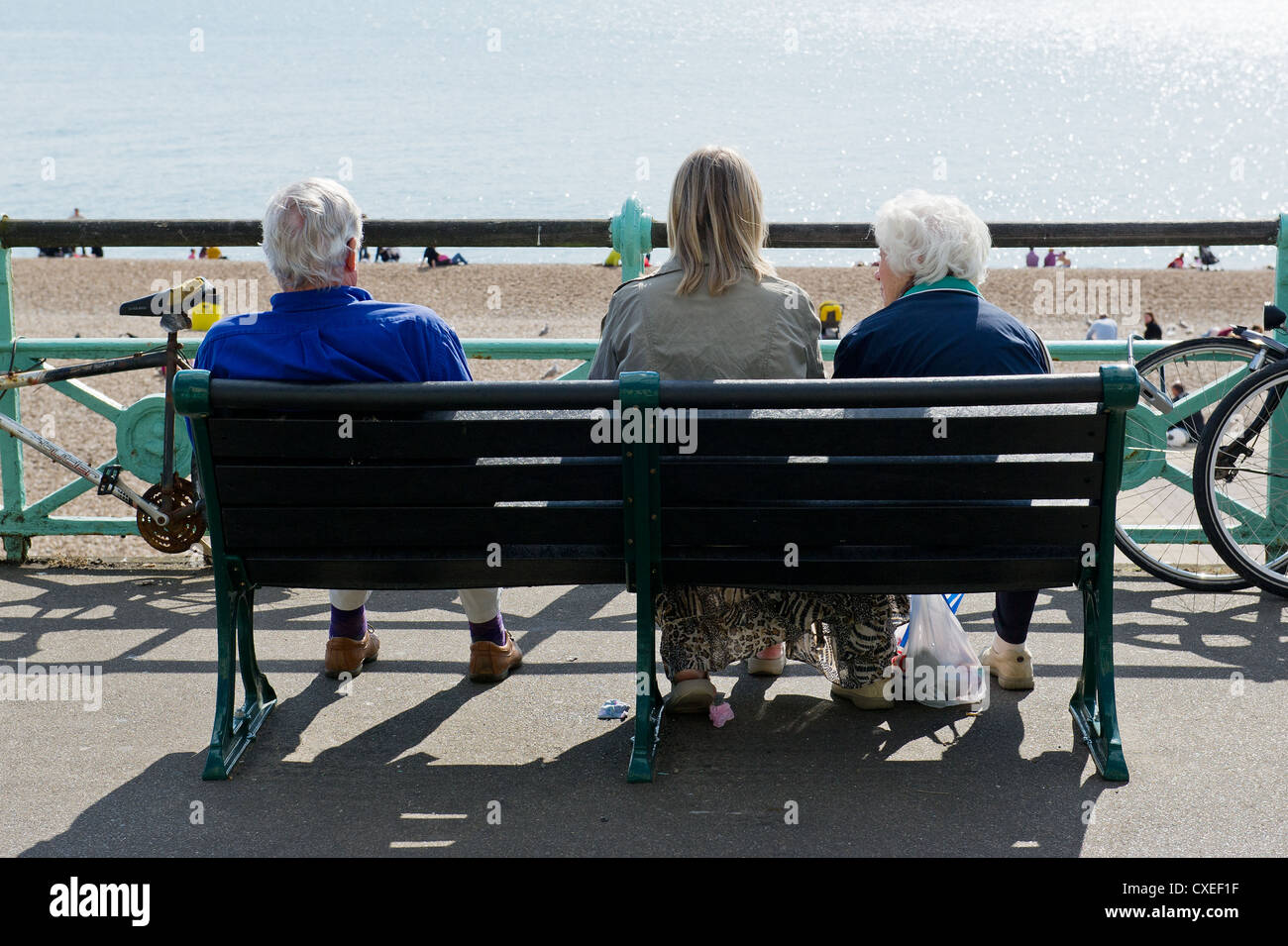 People relaxing on a bench on Brighton seafront Stock Photo - Alamy