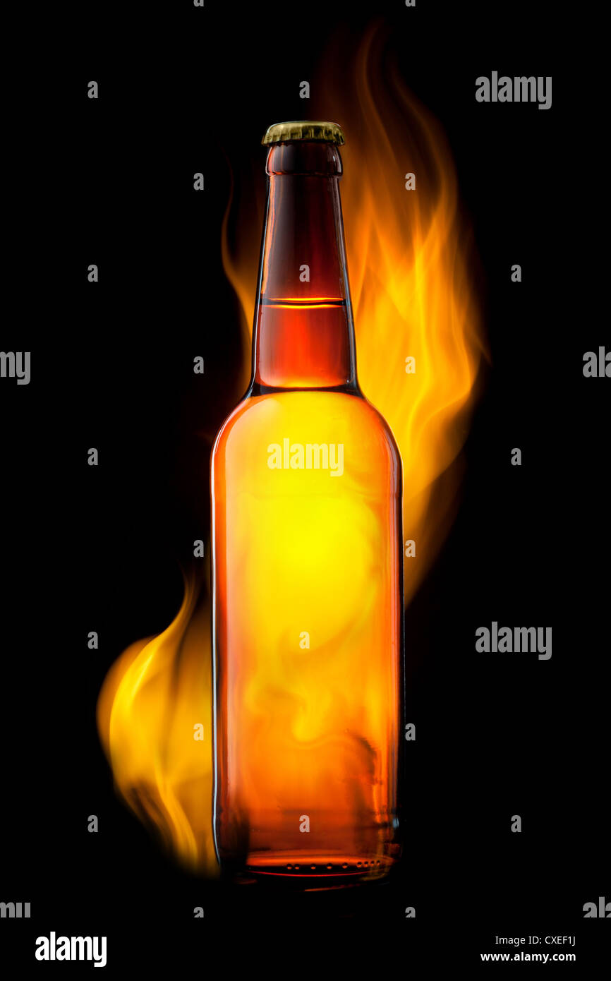 Beer bottle in fire on black Stock Photo - Alamy