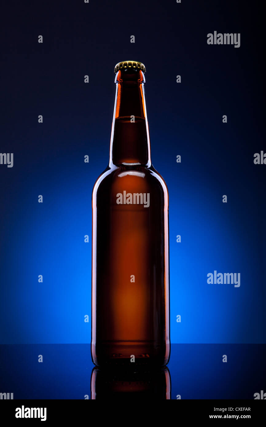 Beer bottle on blue background Stock Photo - Alamy