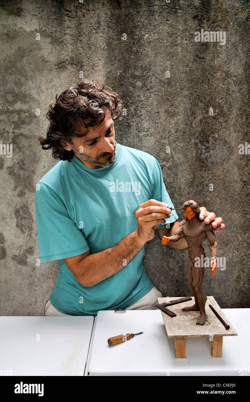 Sculptor at work on a human figurine Stock Photo - Alamy