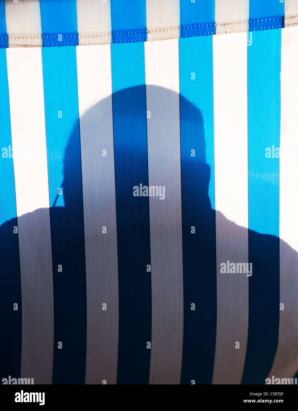 The shadow of a man sitting in a deckchair Stock Photo - Alamy