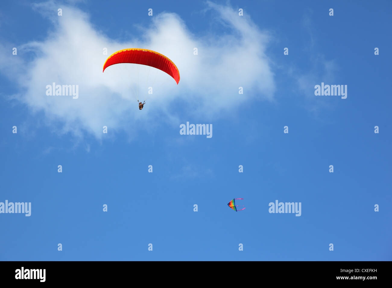 The red parachute flies in the blue sky Stock Photo - Alamy